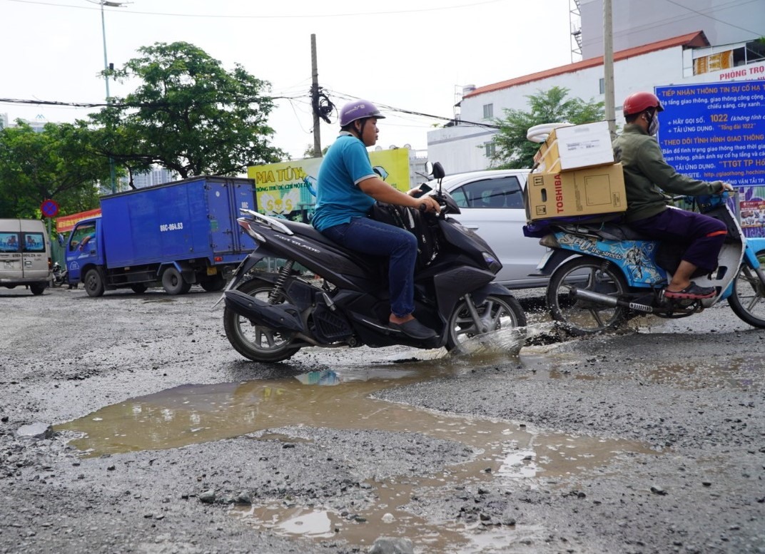 Mặt đường Trần Xuân Soạn nham nhở sau nhiều năm ngập lụt do triều cường