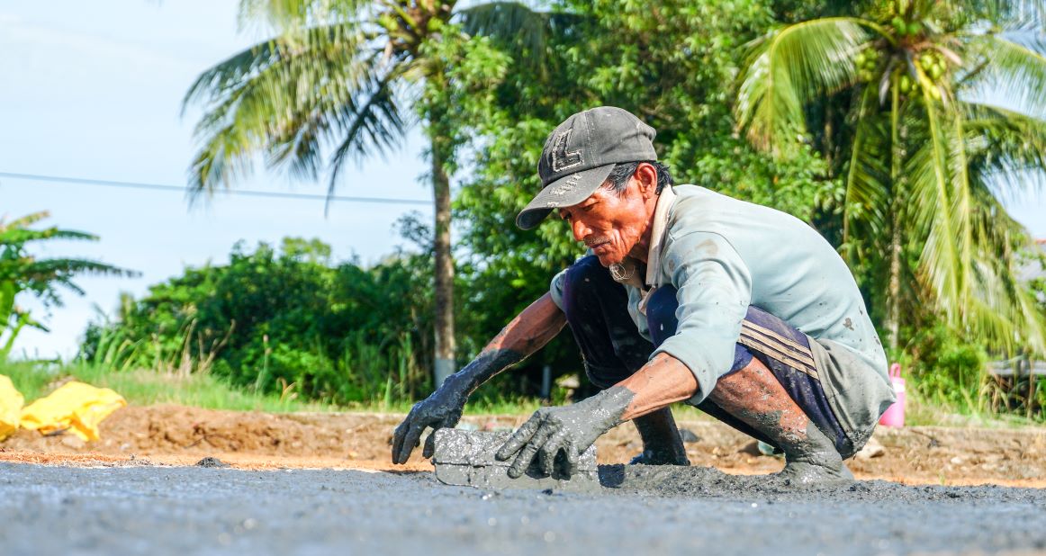 Người lao động trầm mình dưới sông múc bùn non để có thu nhập