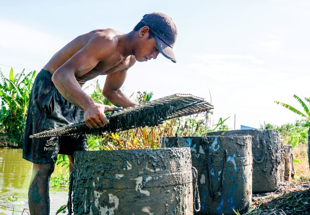 Người lao động trầm mình dưới sông múc bùn non để có thu nhập